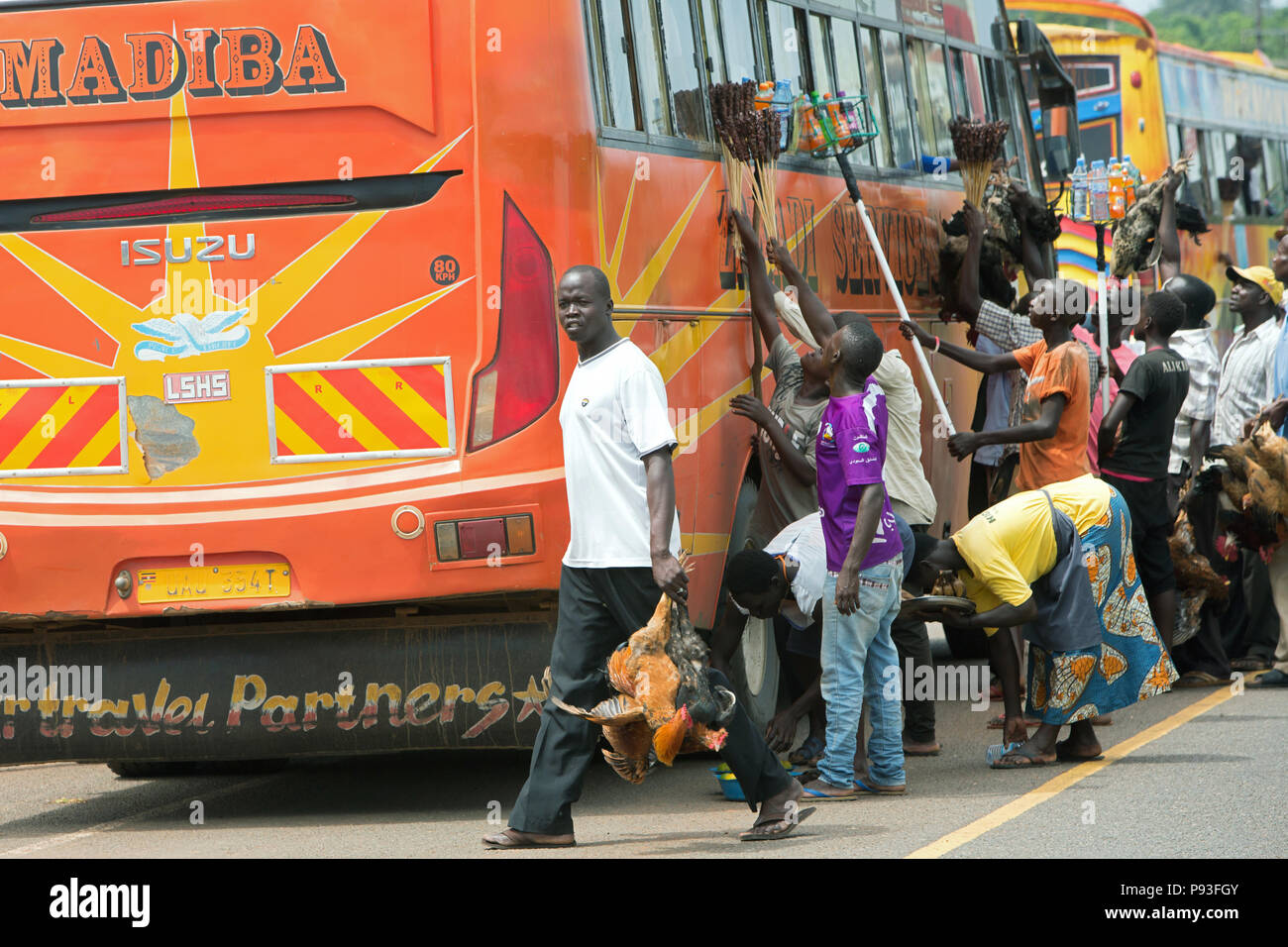 Kamdini, Uganda - At a bus stop, flying merchants offer travelers a ...