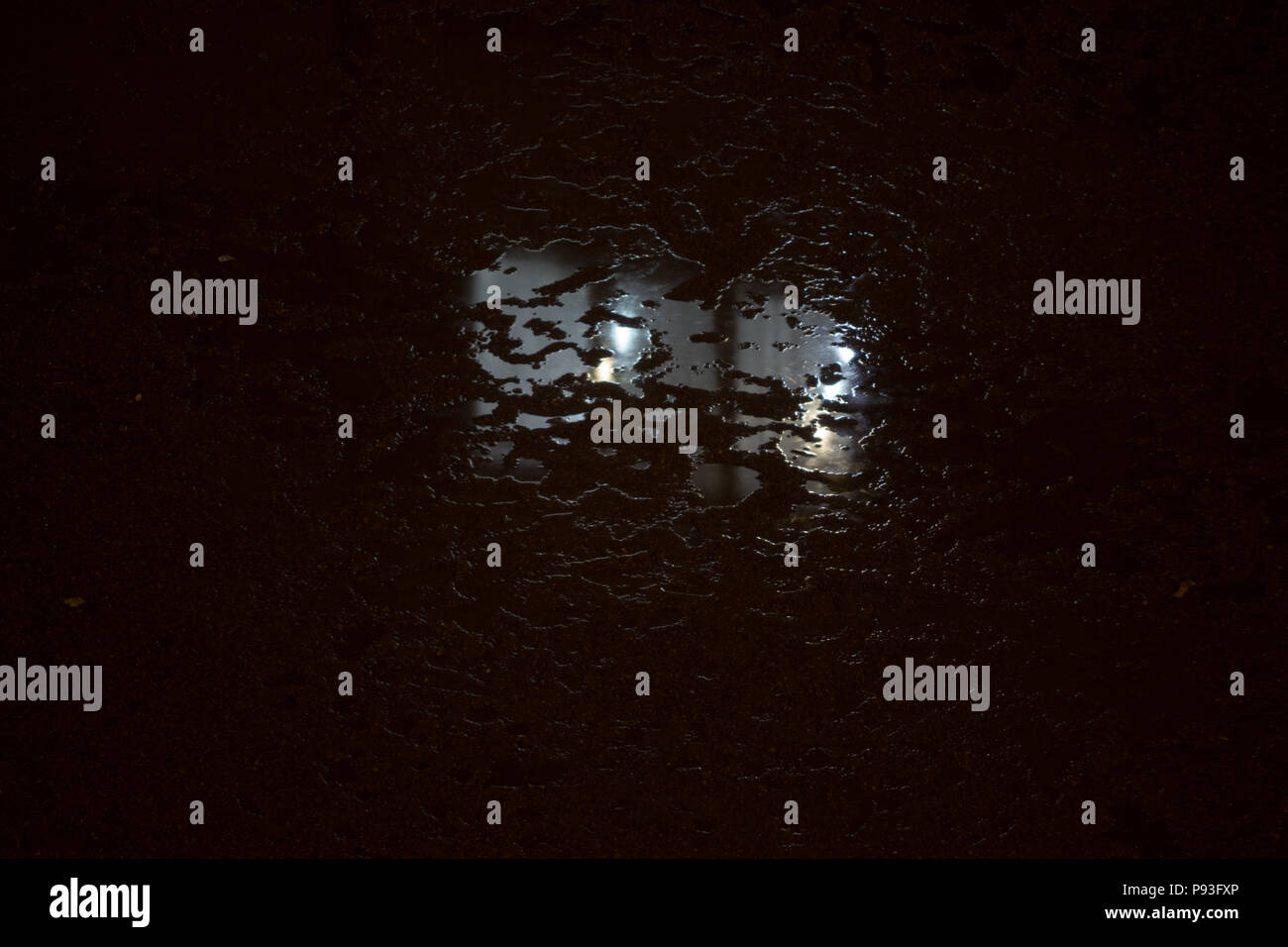 dirty puddle at night. light reflection in it Stock Photo - Alamy
