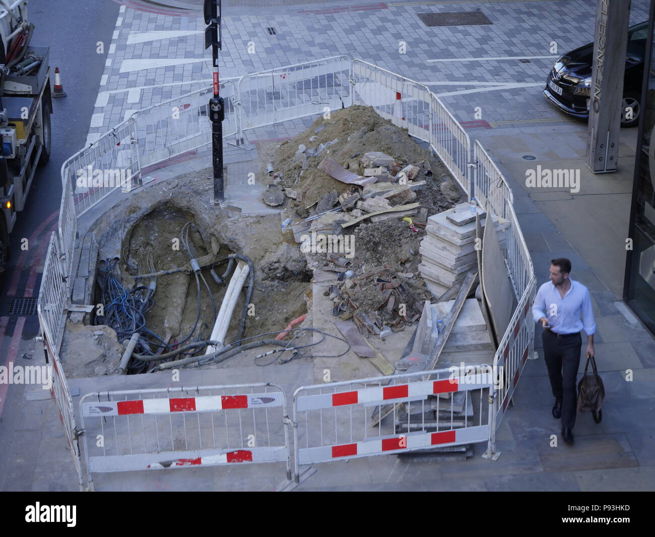 Road works Hole in pavement, dug for access to telecommunications ...