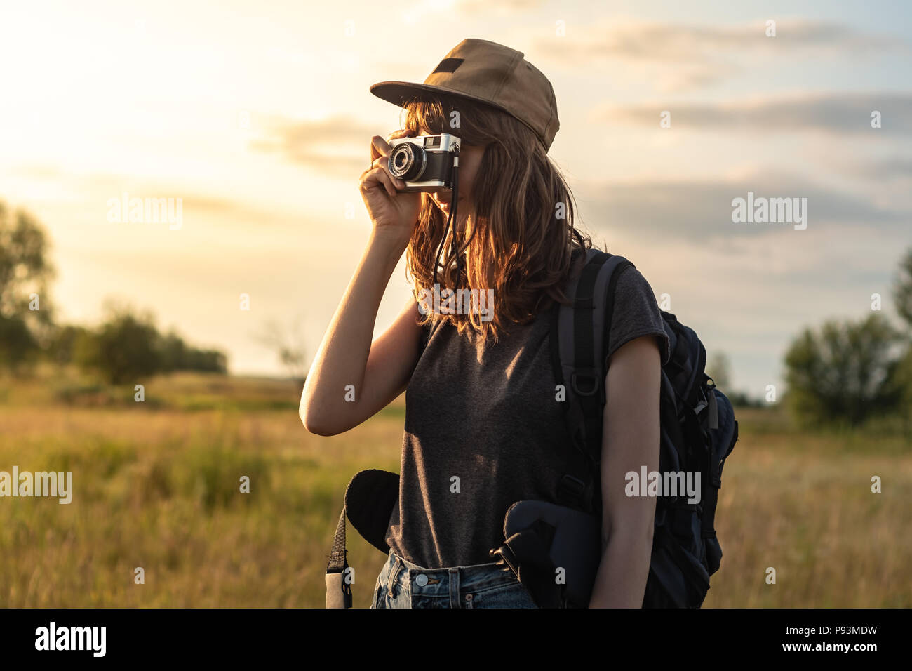 Young female tourist taking photo at hiking trip. Woman with backpack ...