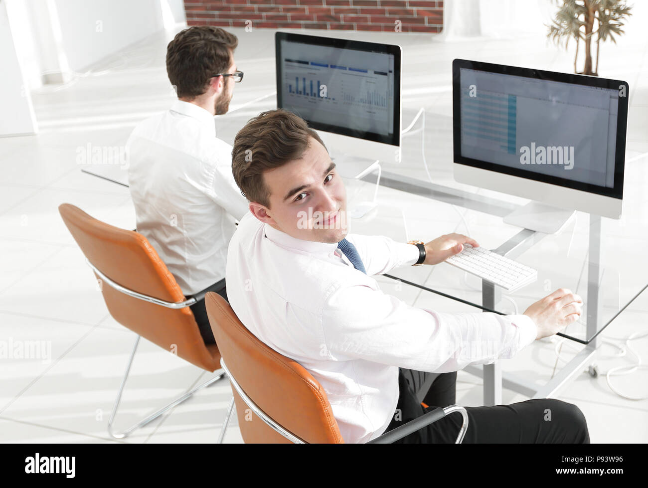office life.employees sitting behind a Desk Stock Photo - Alamy
