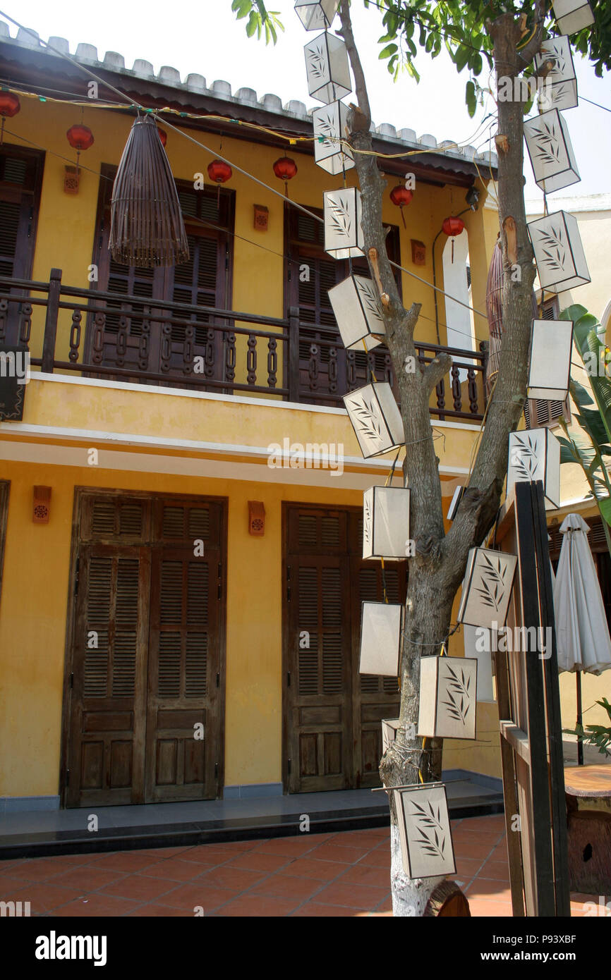 Yellow Vietnamese Building with Wooden Shutters and Lanterns Outside ...
