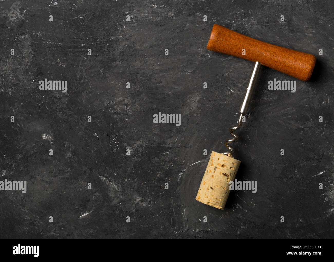 Corkscrew with wine cork on dark wooden board background, flat lay top ...
