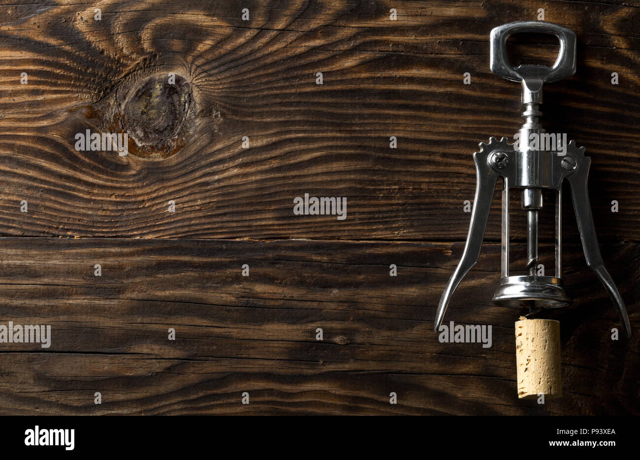 Corkscrew with wine cork on dark wooden board background, flat lay top ...