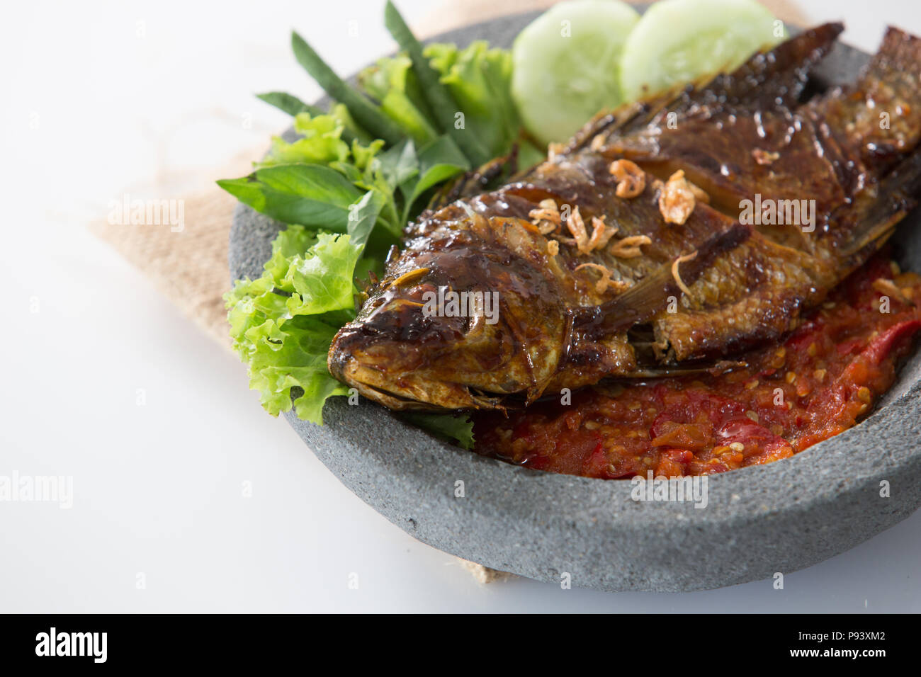fish served with hot chili sauce or sambal in traditional grinder ...
