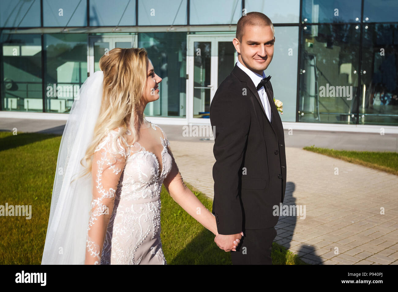 joyful bride and groom walking near the modern building Stock Photo - Alamy