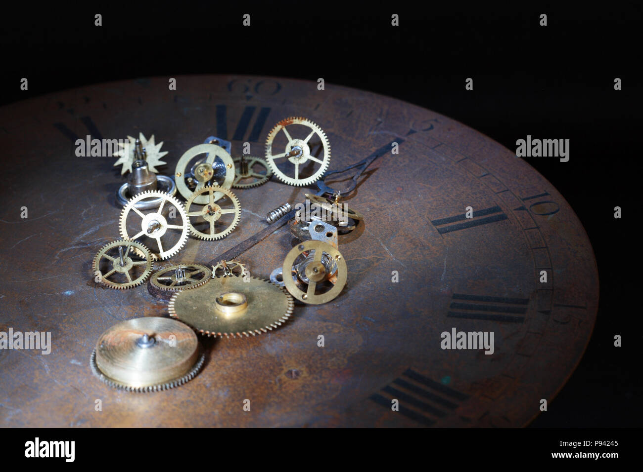 Old watch details lying on vintage rusty clock dial on dark background ...
