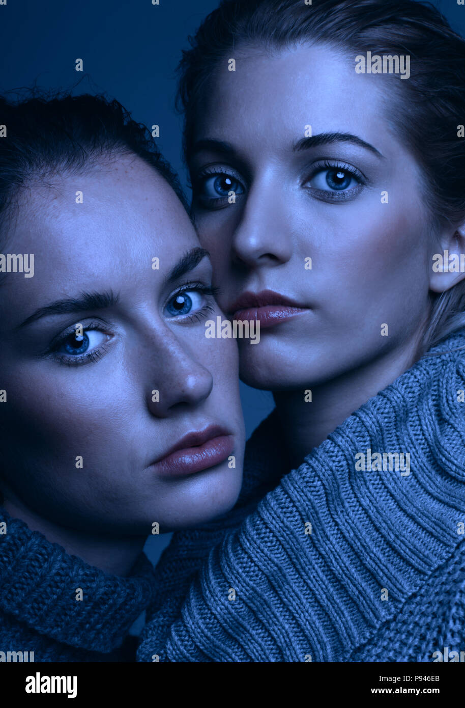 Halloween beauty portrait of two young women in gray sweaters on grey ...