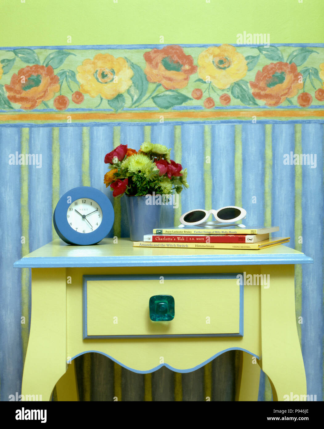 Close-up of yellow table below floral and striped wallpaper Stock Photo ...