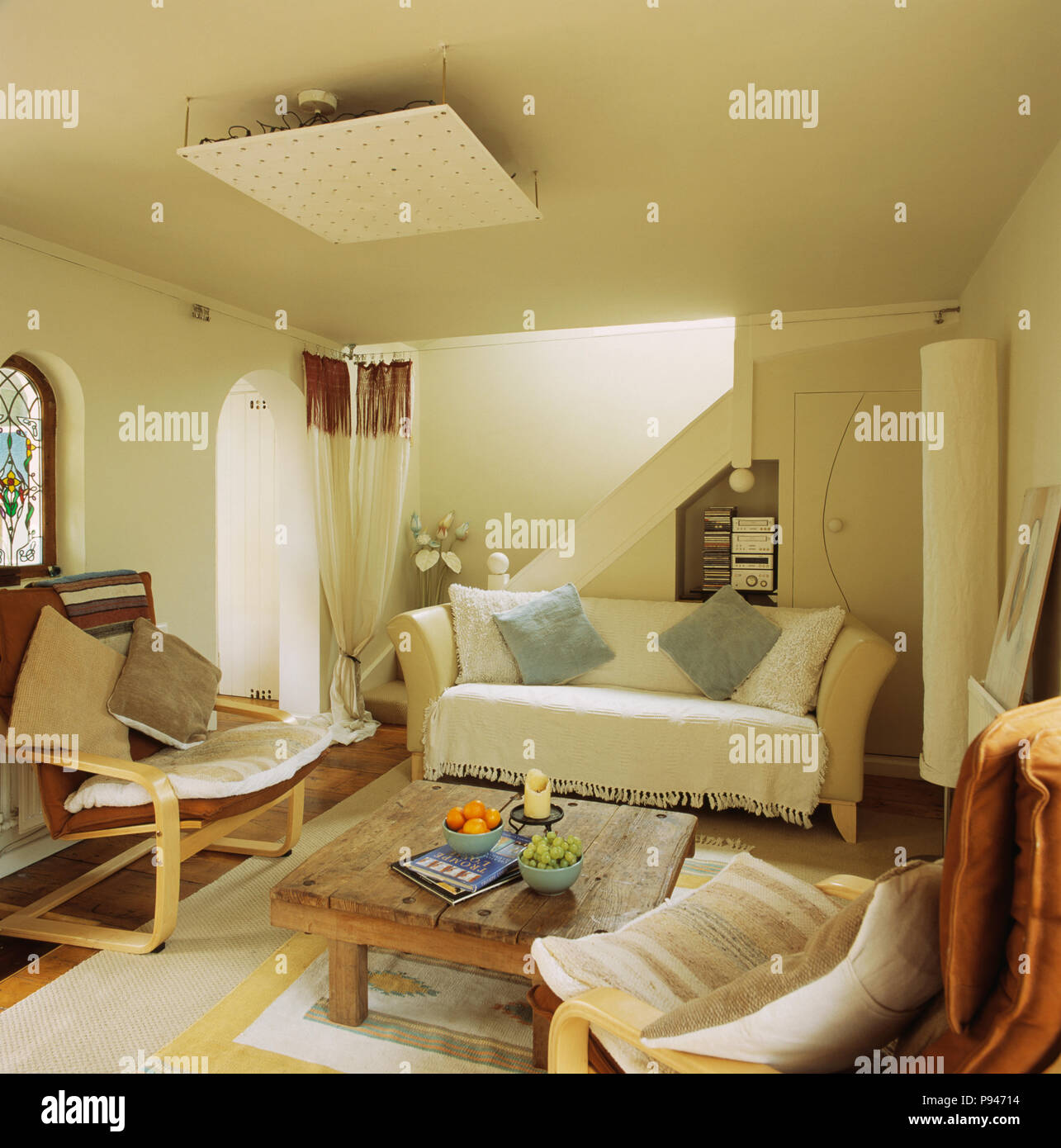 Cream throw on modern sofa in small cream living room Stock Photo - Alamy