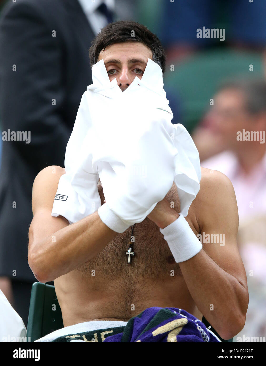 Novak Djokovic changes his shirt during a break in play on day twelve ...