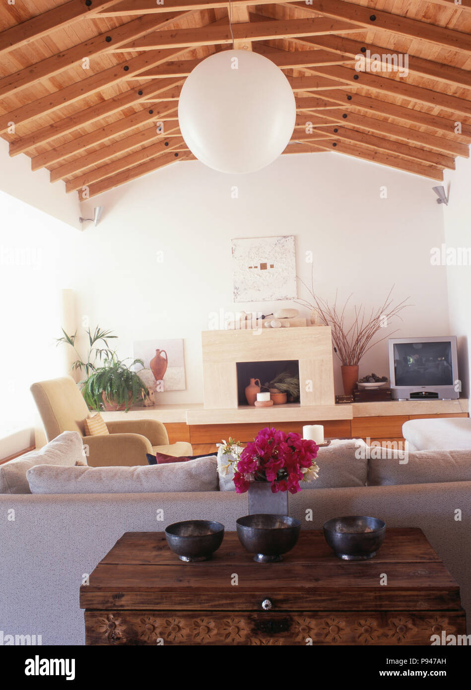 Three bowls on wooden chest behind sofa in modern living room with ...