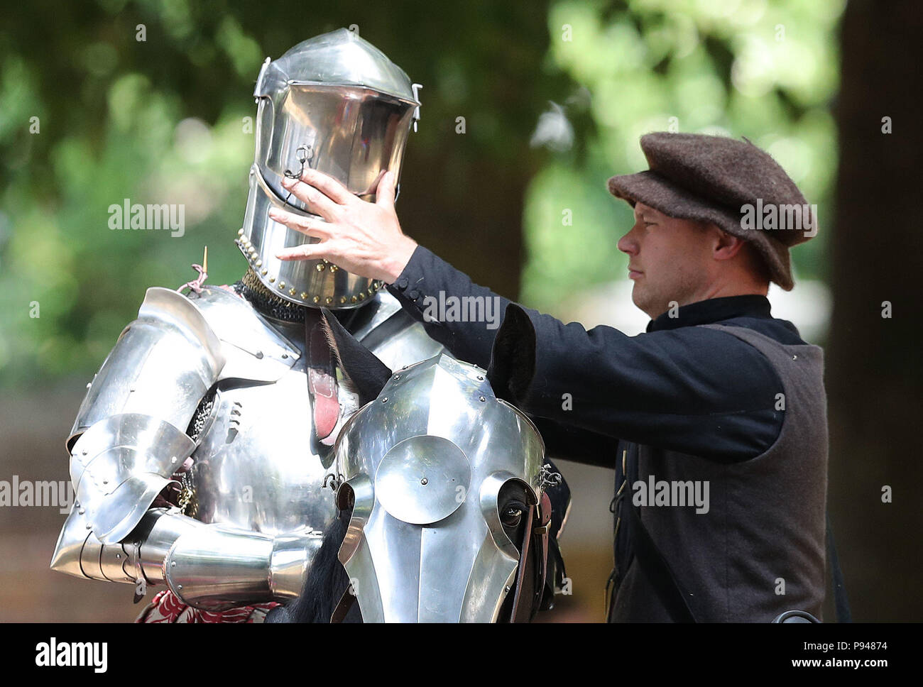 A knight on horse back has his helmet fitted as he waits the start of ...