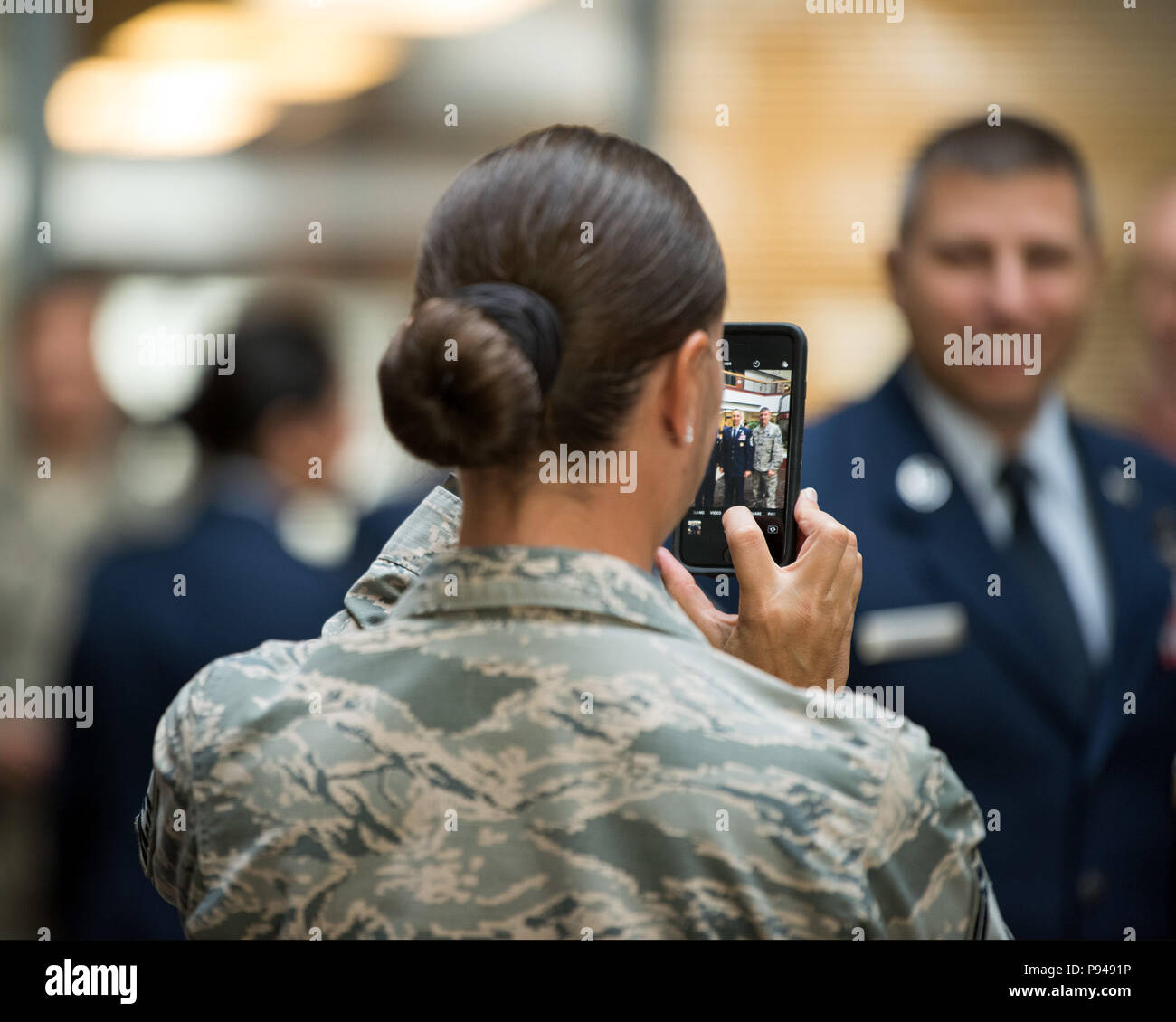 A service member takes a photo prior to the Change of Command ceremony ...