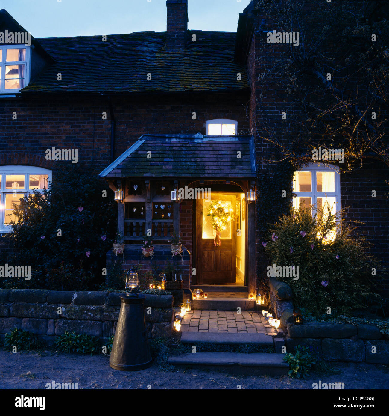 Lights on inside traditional country house at Christmas Stock Photo - Alamy