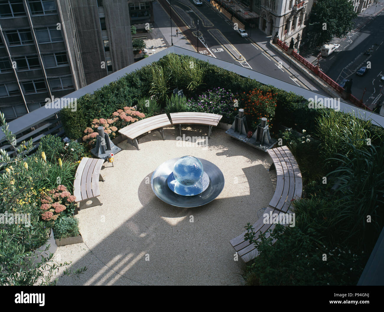 Birdseye view of curved benches around chrome bubble pool on lushly ...