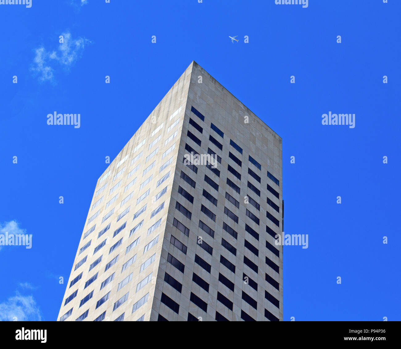 The top of a towering skyscraper in front of blue sky Stock Photo - Alamy
