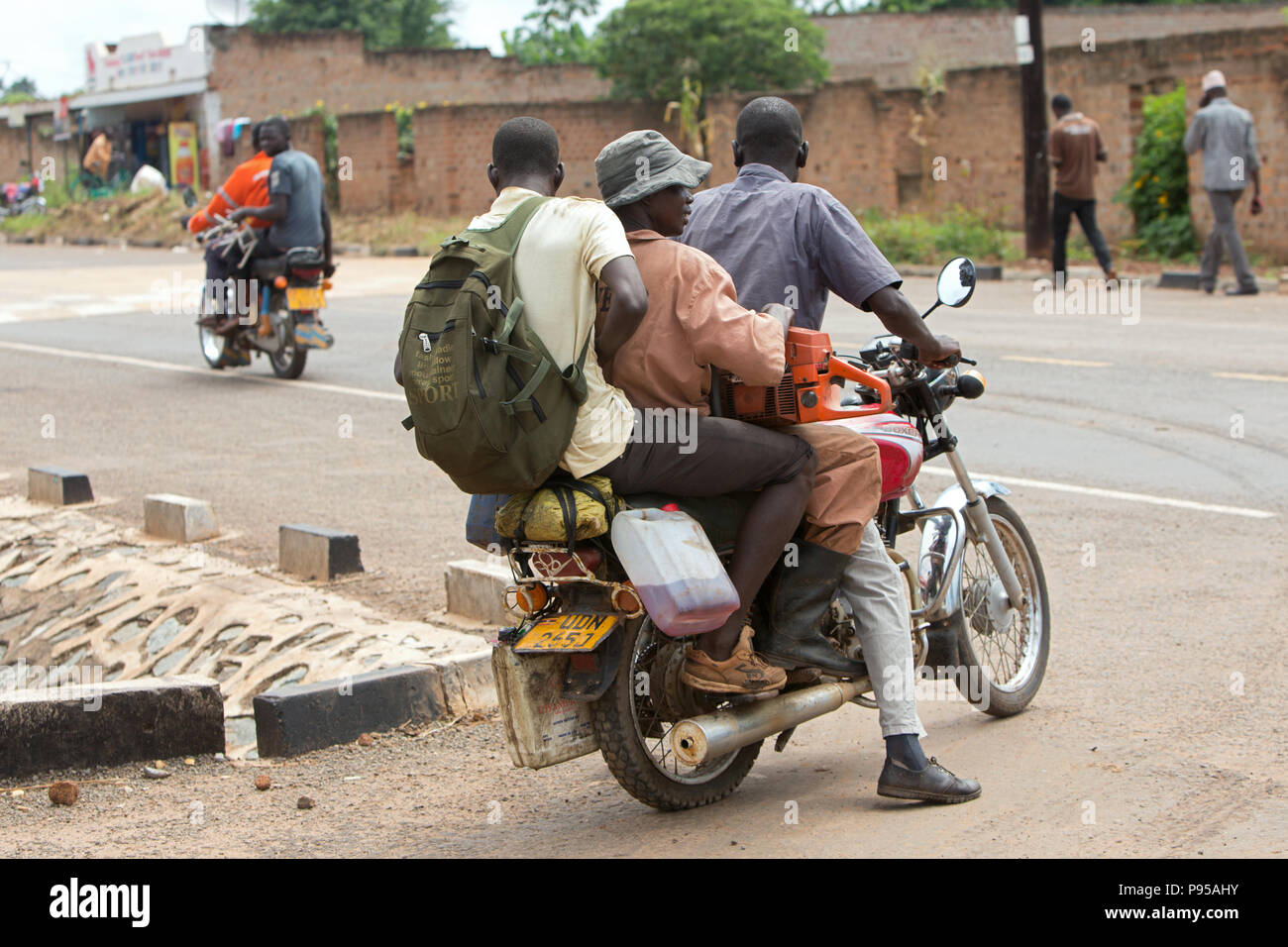 Kamdini, Uganda - Street scene with people and motorcycles. Three men ...