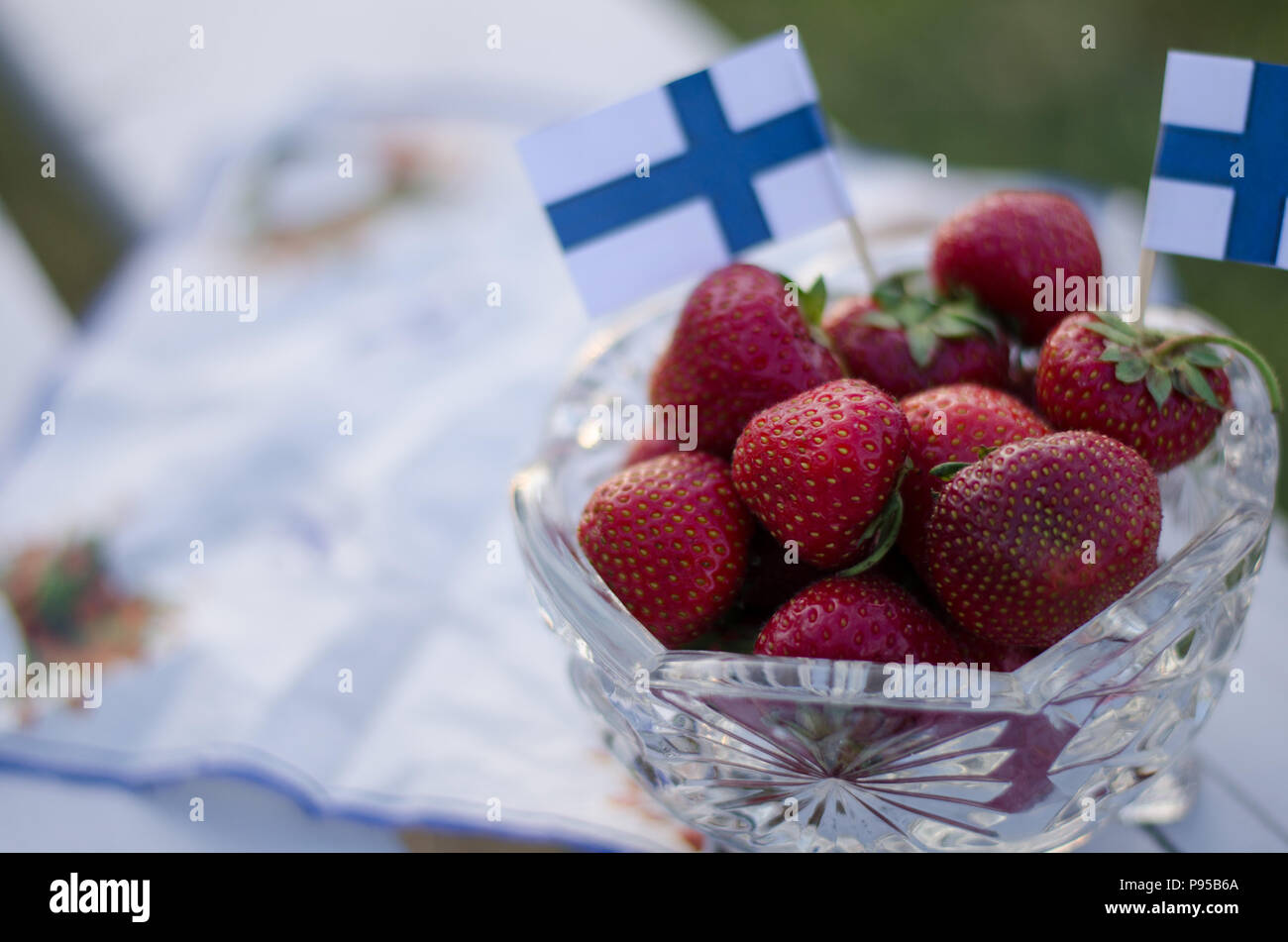Strawberries in a bowl with finnish flags with grass in the background ...