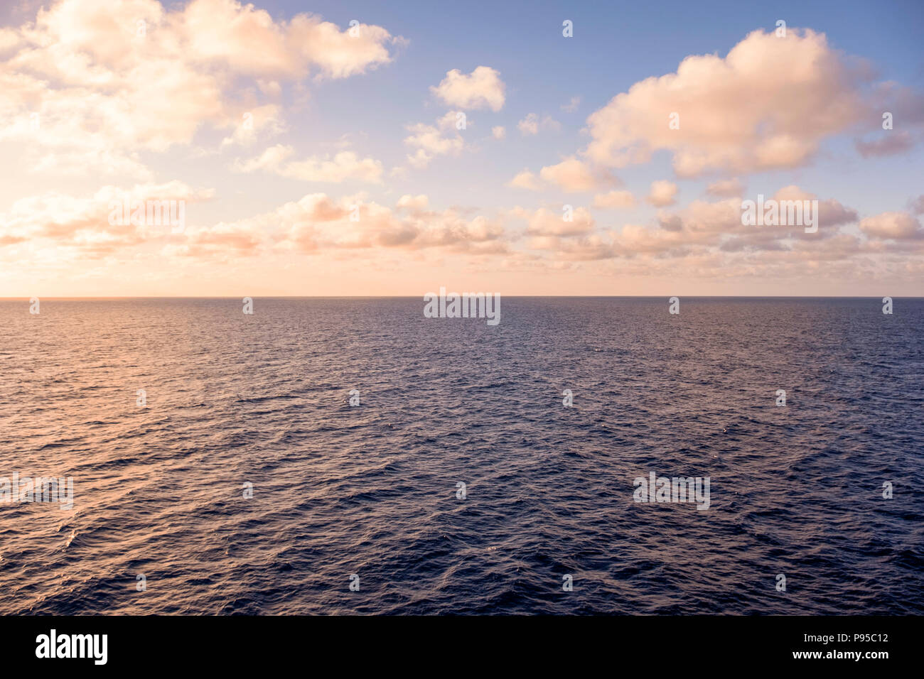 Vast blue ocean with moderate waves on during twilight Stock Photo - Alamy
