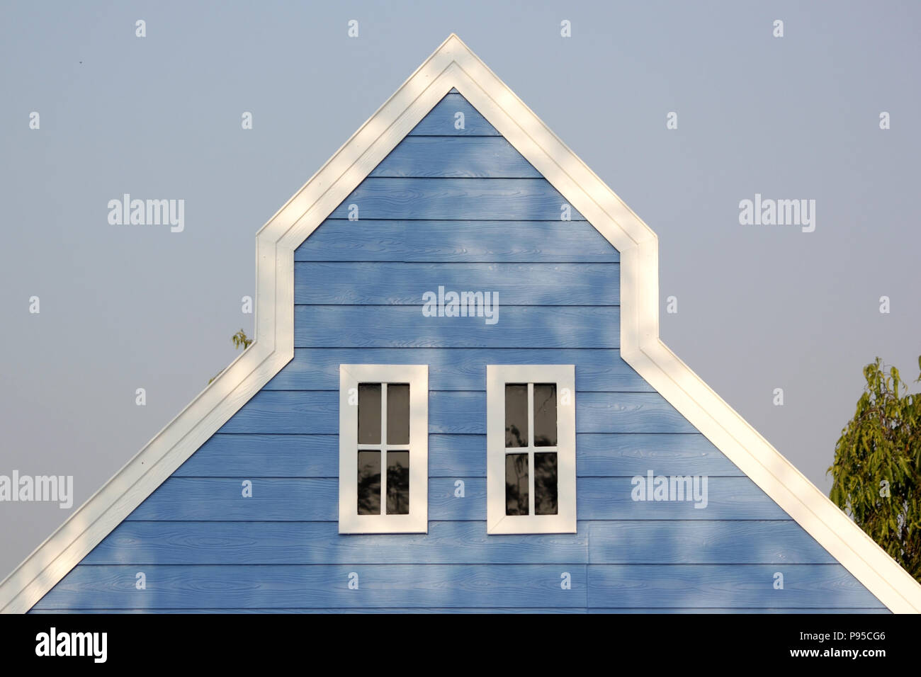 photo of gable roof with white windows on wooden house Stock Photo - Alamy