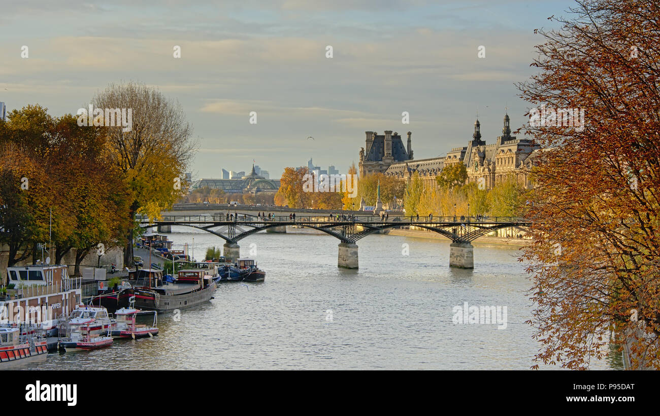 Bridge over river Seine, with boats moored along a quay with trees and ...