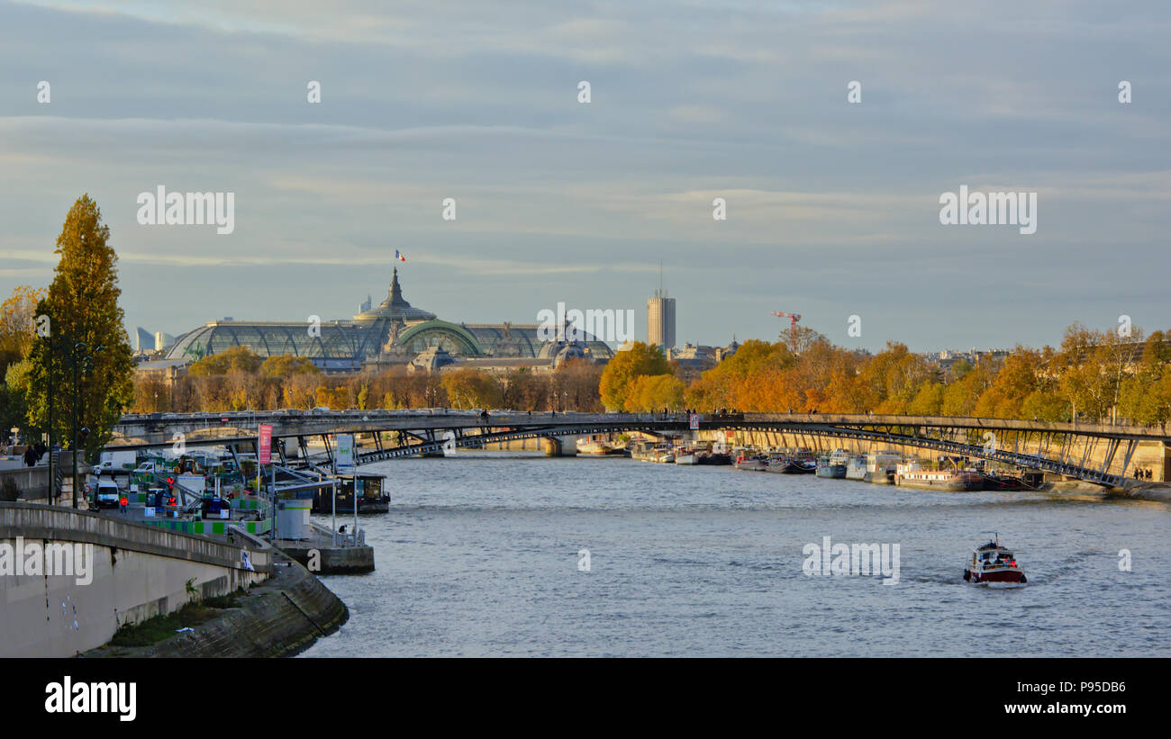 Bridge over river Seine, with autumn trees along the sides and roof of ...