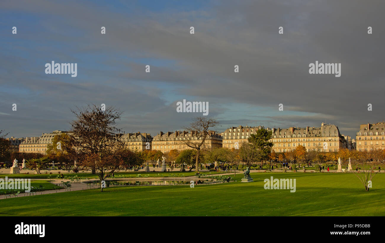 People hanging out in grass fields of the Tuileries garden, with ...