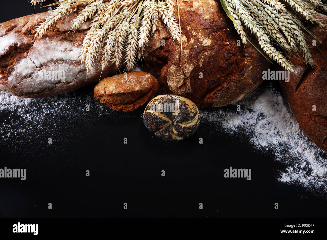 Different kinds of bread and bread rolls on board from above. Kitchen ...