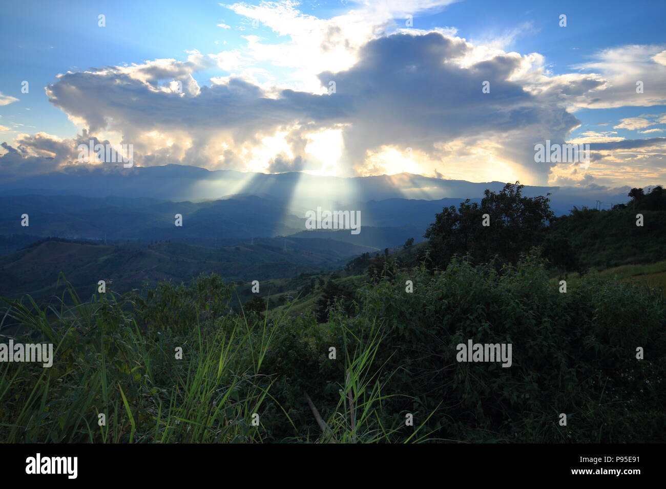Dramatic god lights passing through clouds and shining on mountain ...