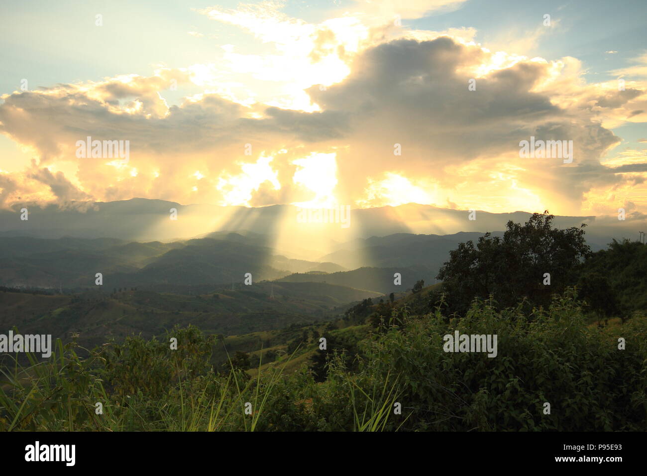 Dramatic god lights passing through clouds and shining on mountain ...