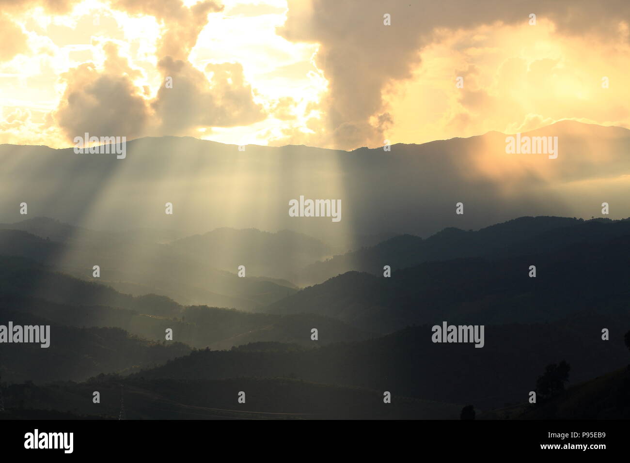 Dramatic god lights passing through clouds and shining on mountain ...