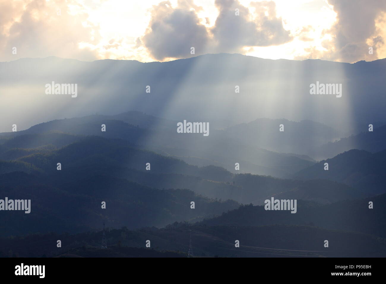 Dramatic god lights passing through clouds and shining on mountain ...