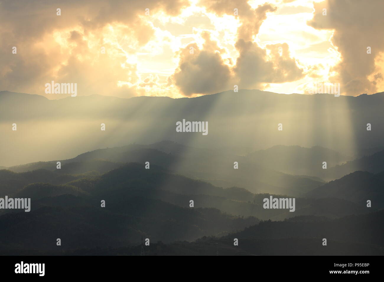 Dramatic god lights passing through clouds and shining on mountain ...