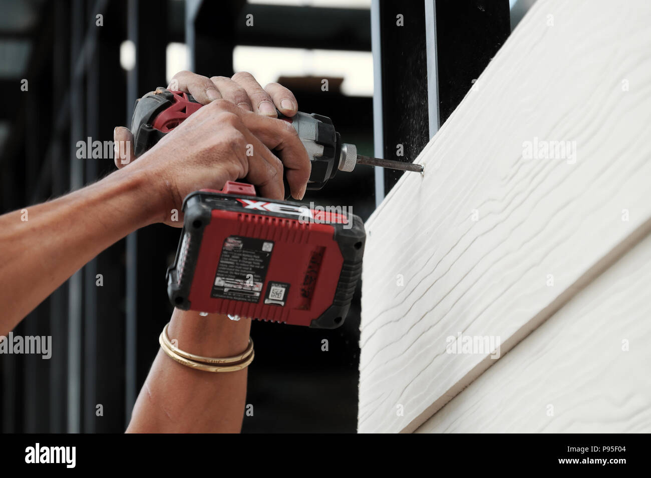 Vietnamese man work with hand drill drilling on wall to screw shot when ...