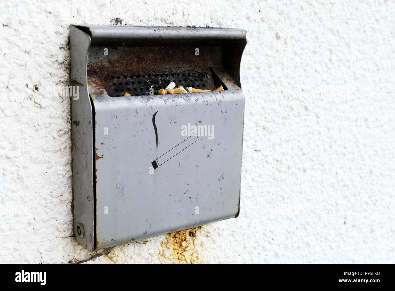 Cigarette smokers ashtray outdoors metal on wall wall space background ...