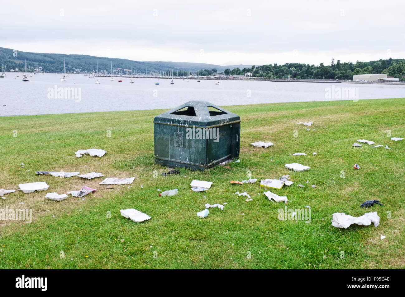 litter garbage rubbish in park outside of bin lying on ground green ...