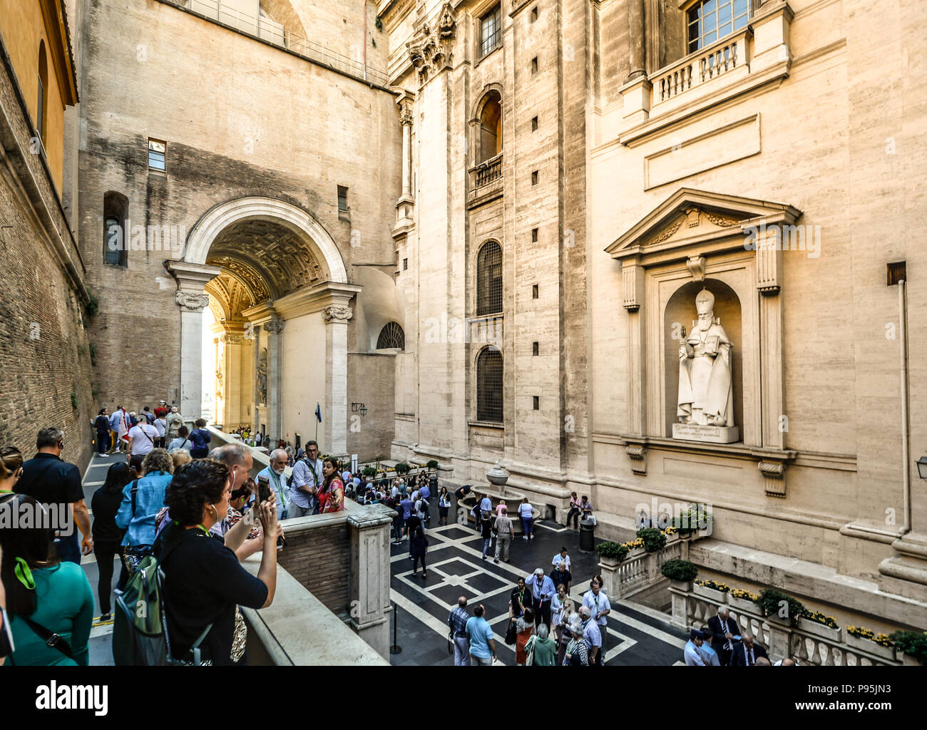 Tourists drink from the water fountain just inside the massive gated ...