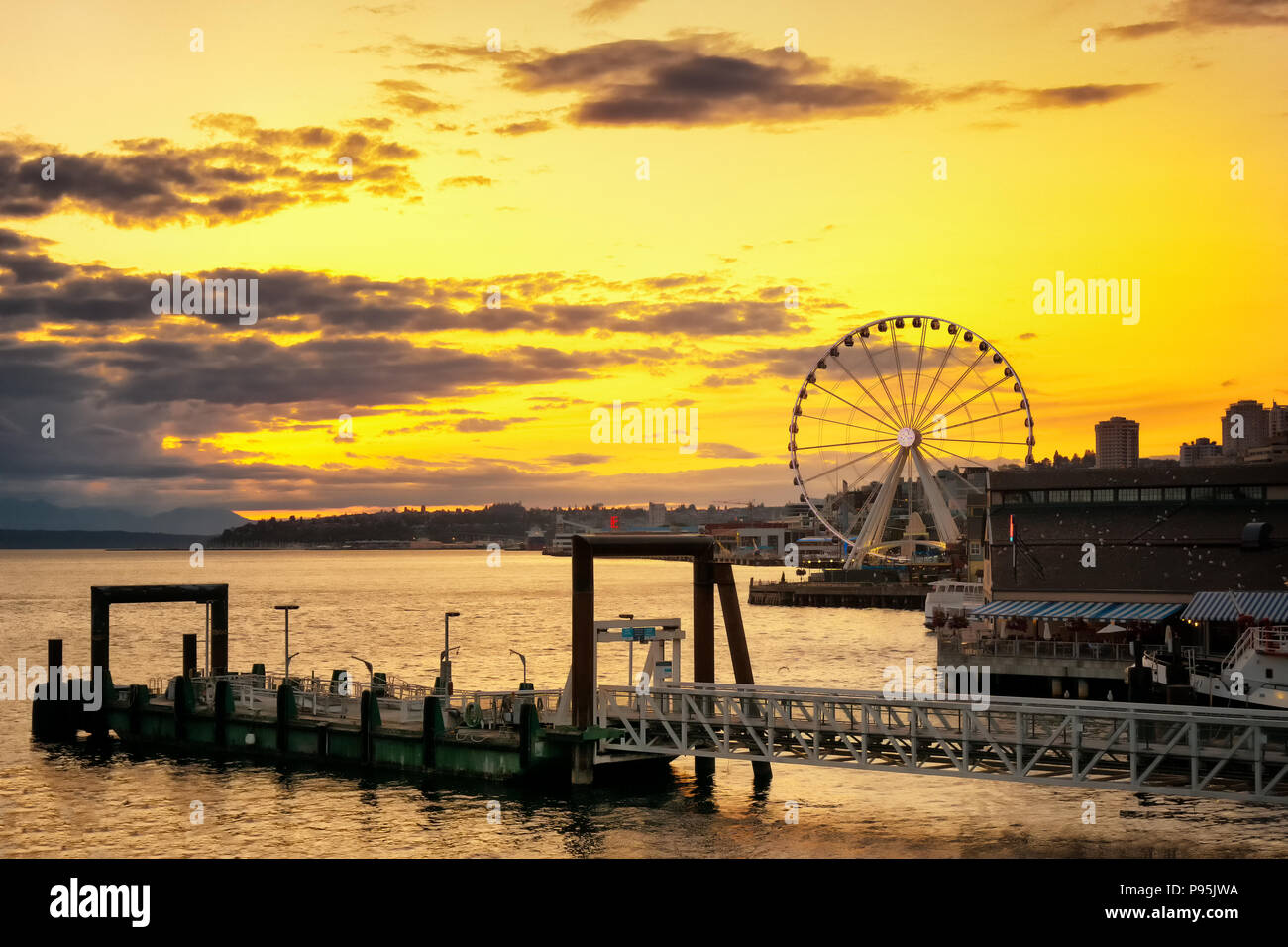 Seattle skyline at dusk with the great wheel and a vibrant yellow sky ...