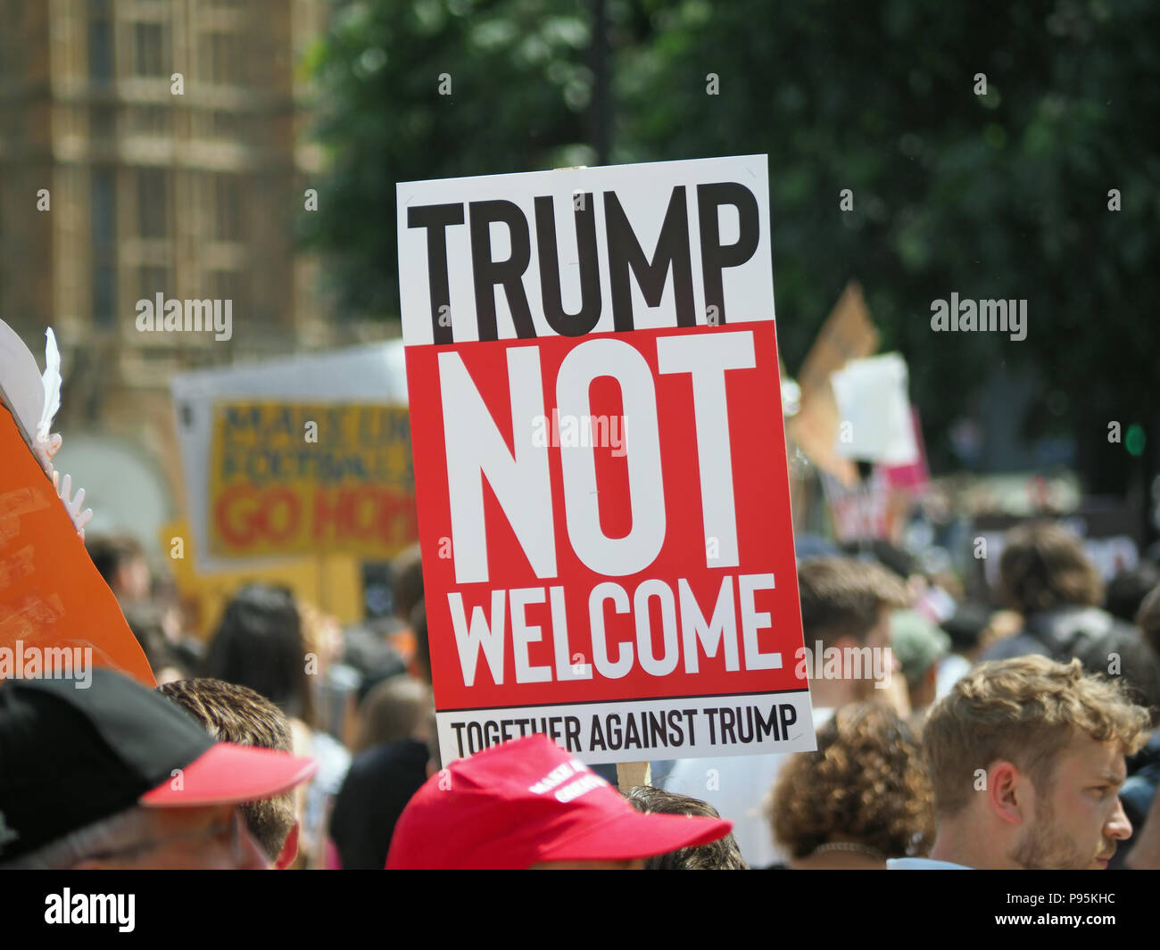 View of "Trump Not Welcome" banners and placards waved by crowds at the ...