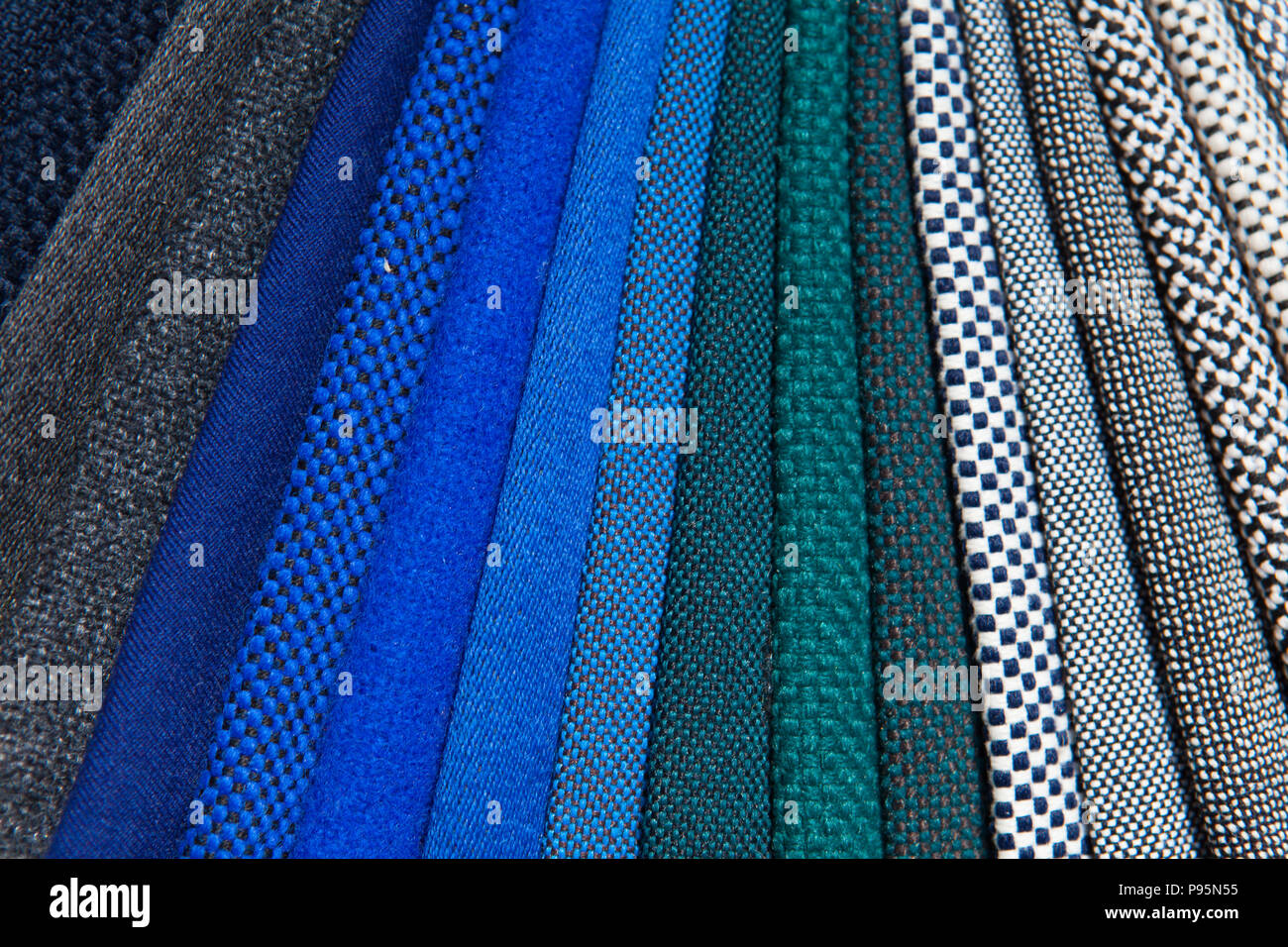 Wide range of colourful fabrics lay out side by side on display to ...