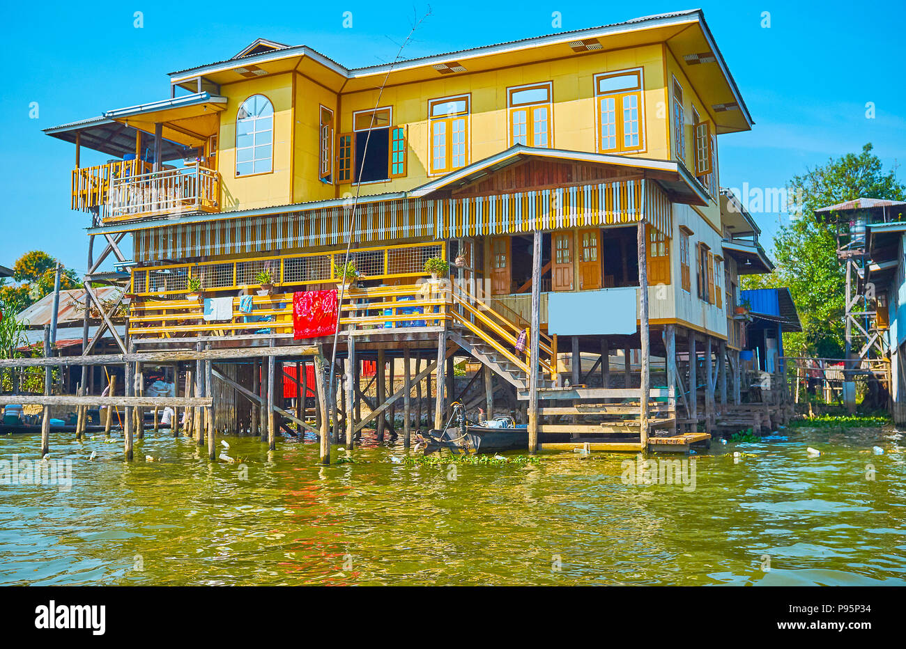 The scenic colorful wooden two-story house on stilts on Inle Lake ...