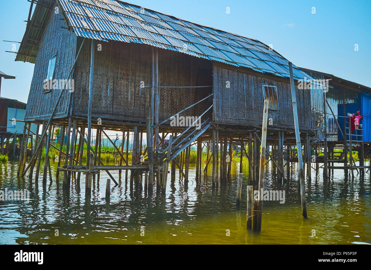 The old house on tall stilts with walls of weaved bamboo panels ...