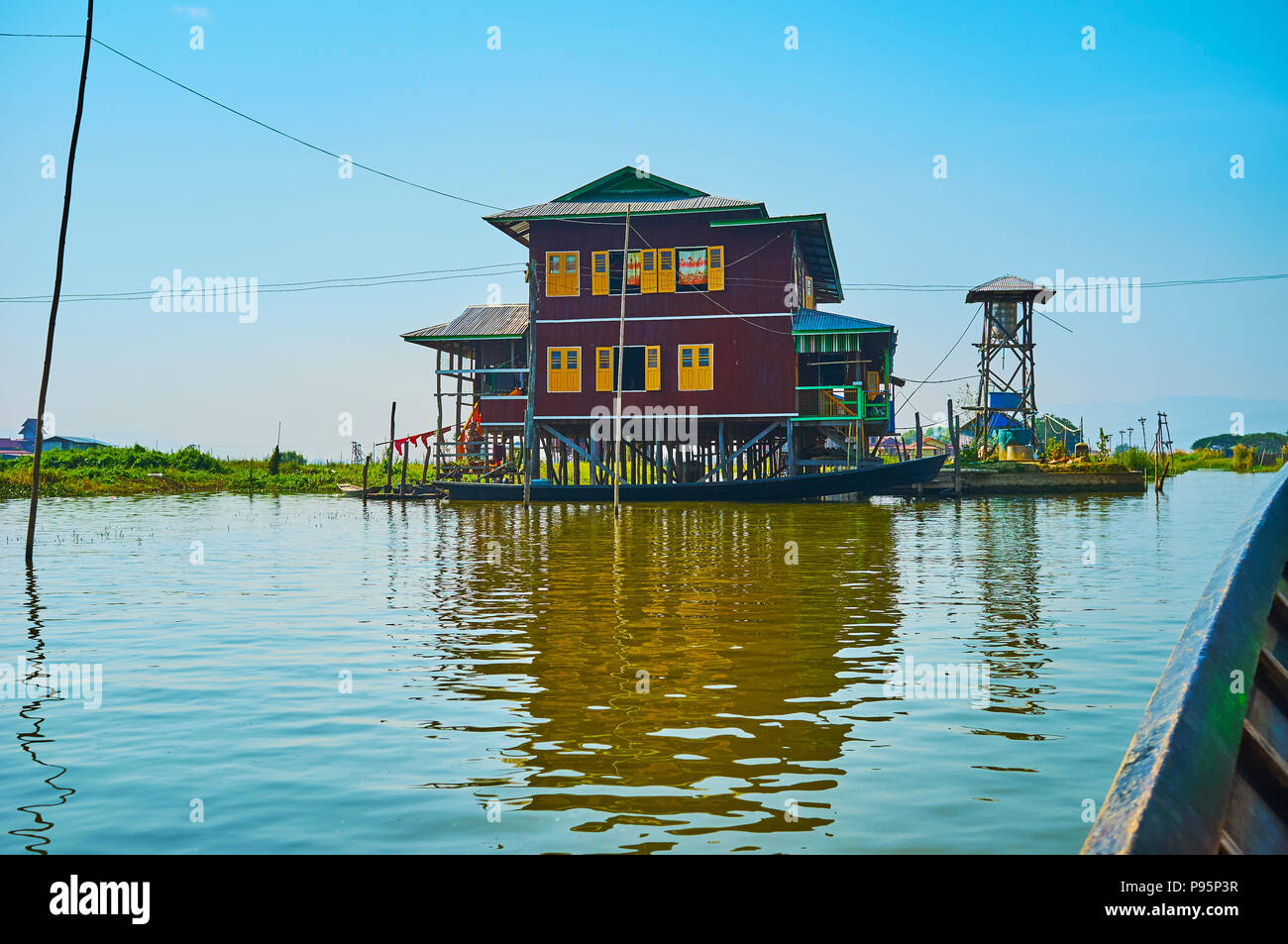 The residential house on stilts with timber water tower, standing next ...