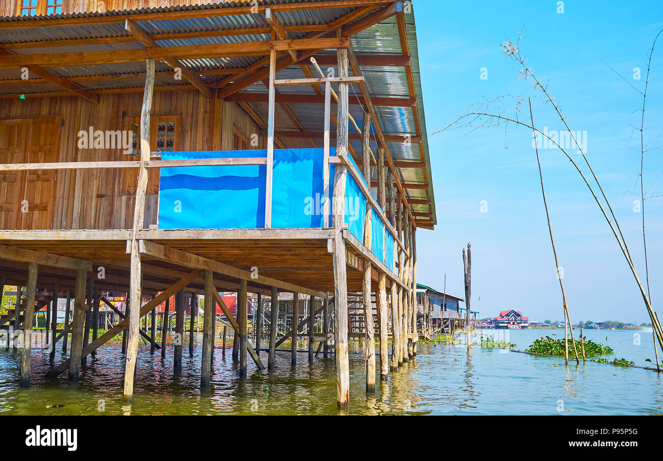 Floating along the wooden house on stilts in Inpawkhon village on Inle ...