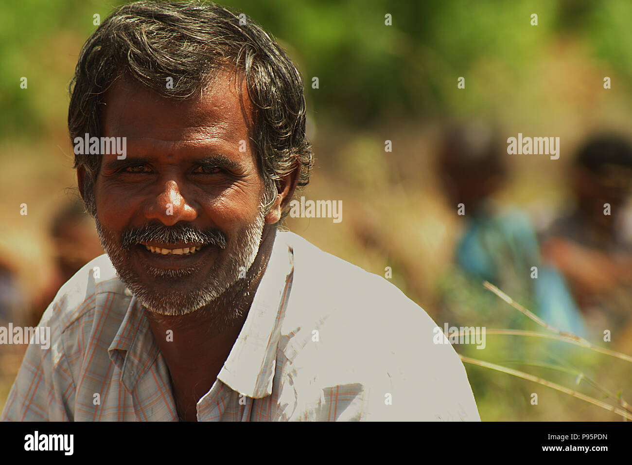 smiling indian village man sitting at a paddy field Stock Photo - Alamy