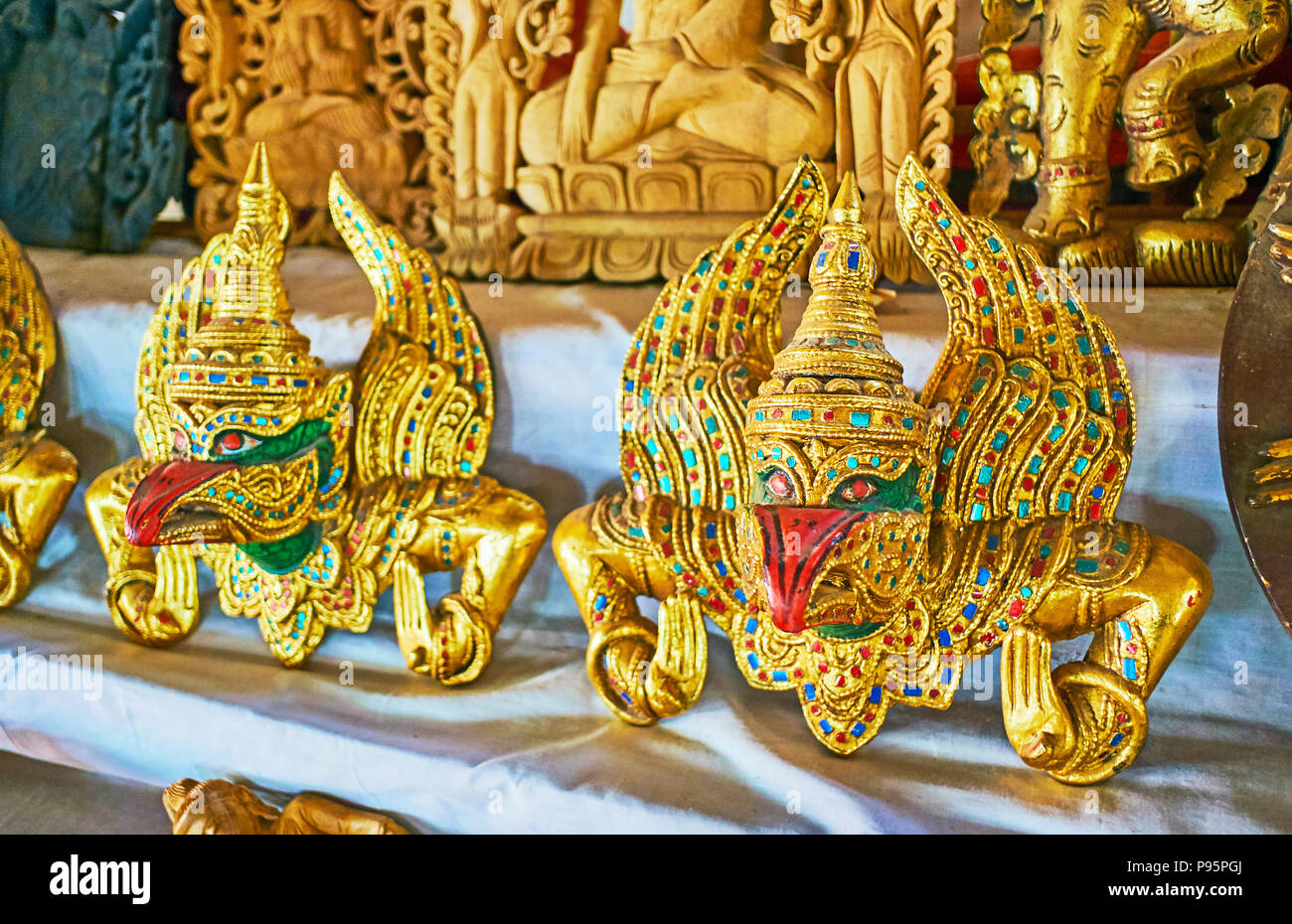Sculptures of golden Garuda mythical birds, decorated with inlays in ...