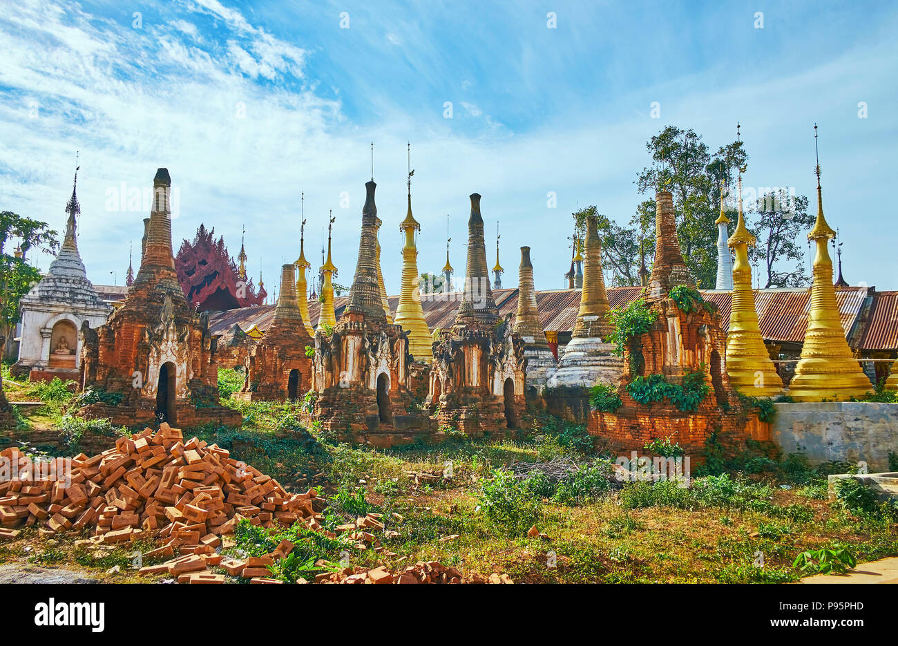 The rows of ruined brick and restored golden stupas on territory of ...