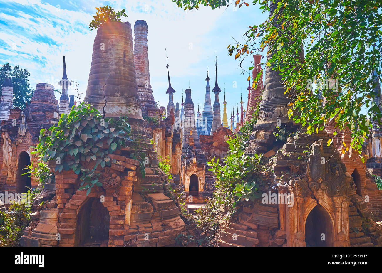 The ruins of ancient stupas of Nyaung Ohak are overgrown with lush ...