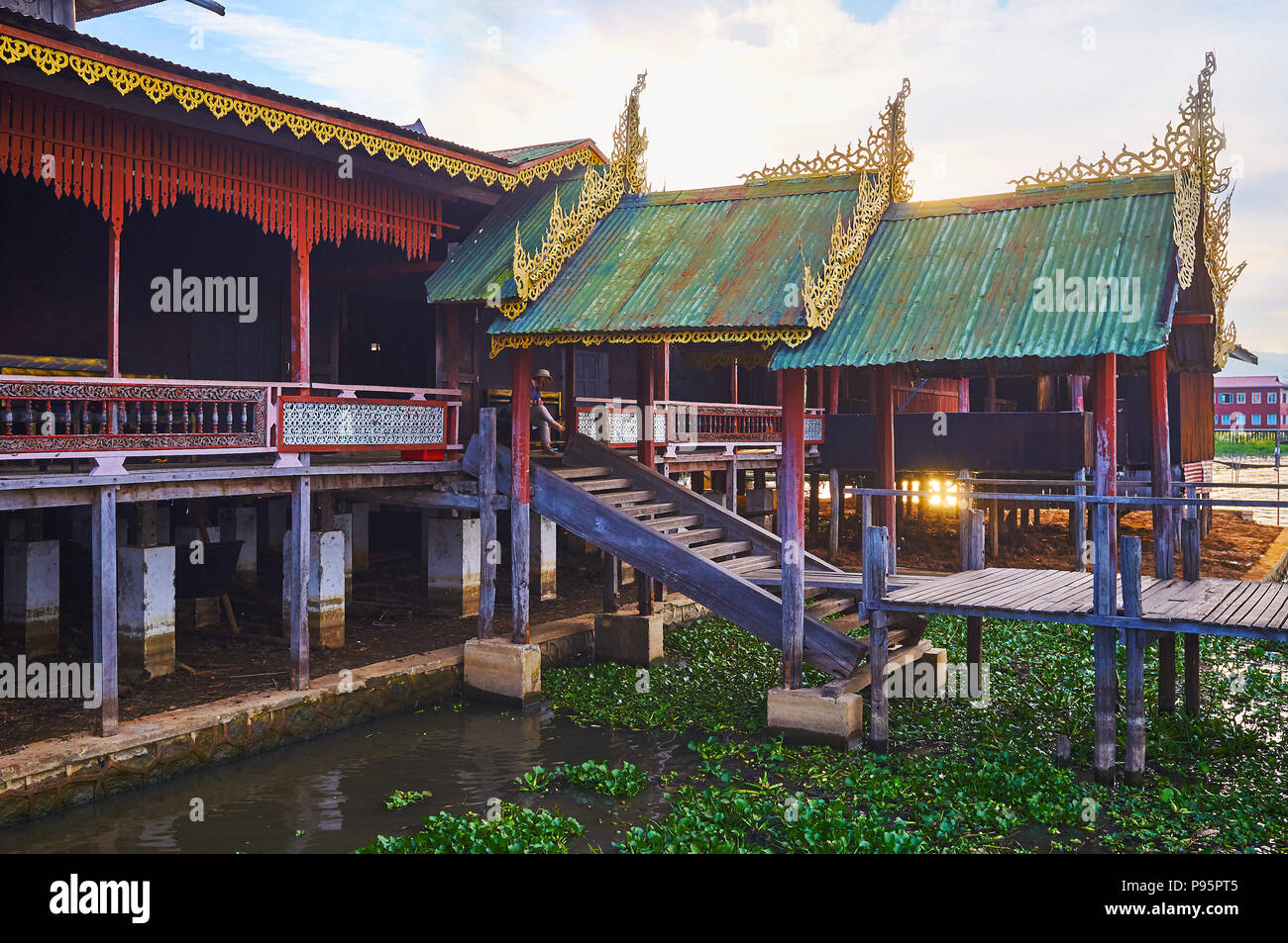 The scenic stilt porch of Nga Phe Chaung monastery with carved golden ...